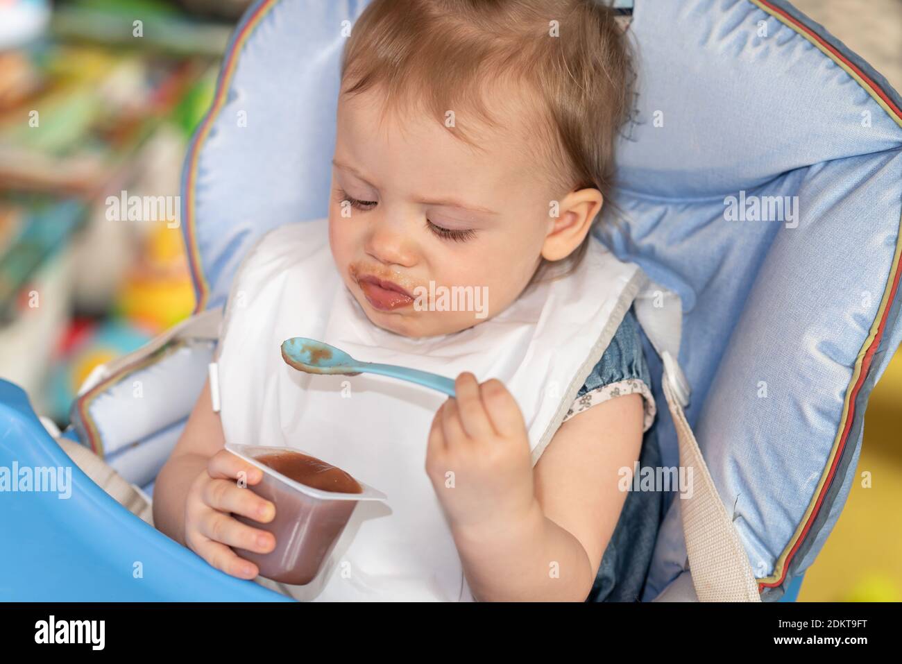 Cute baby girl eating tasty food and learning using spoon Stock Photo ...