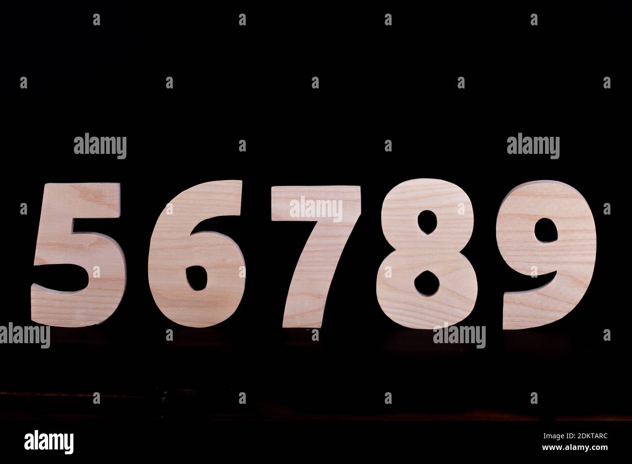 Large wooden numbers 5 6 7 8 9. Hardwood characters on a black ...