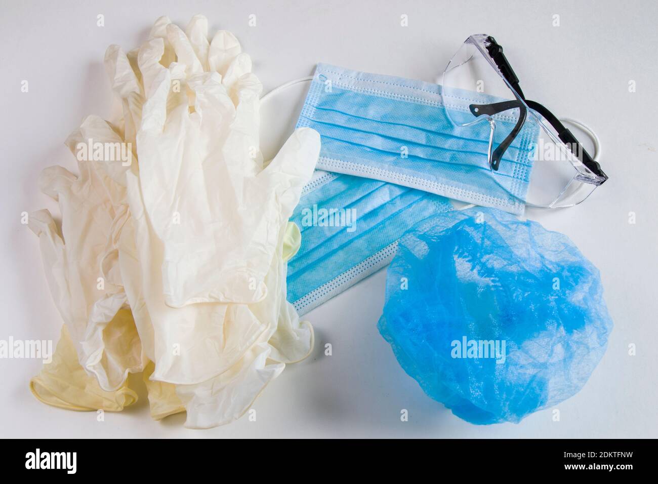 Medical gloves, face masks and safety glasses on the white background ...