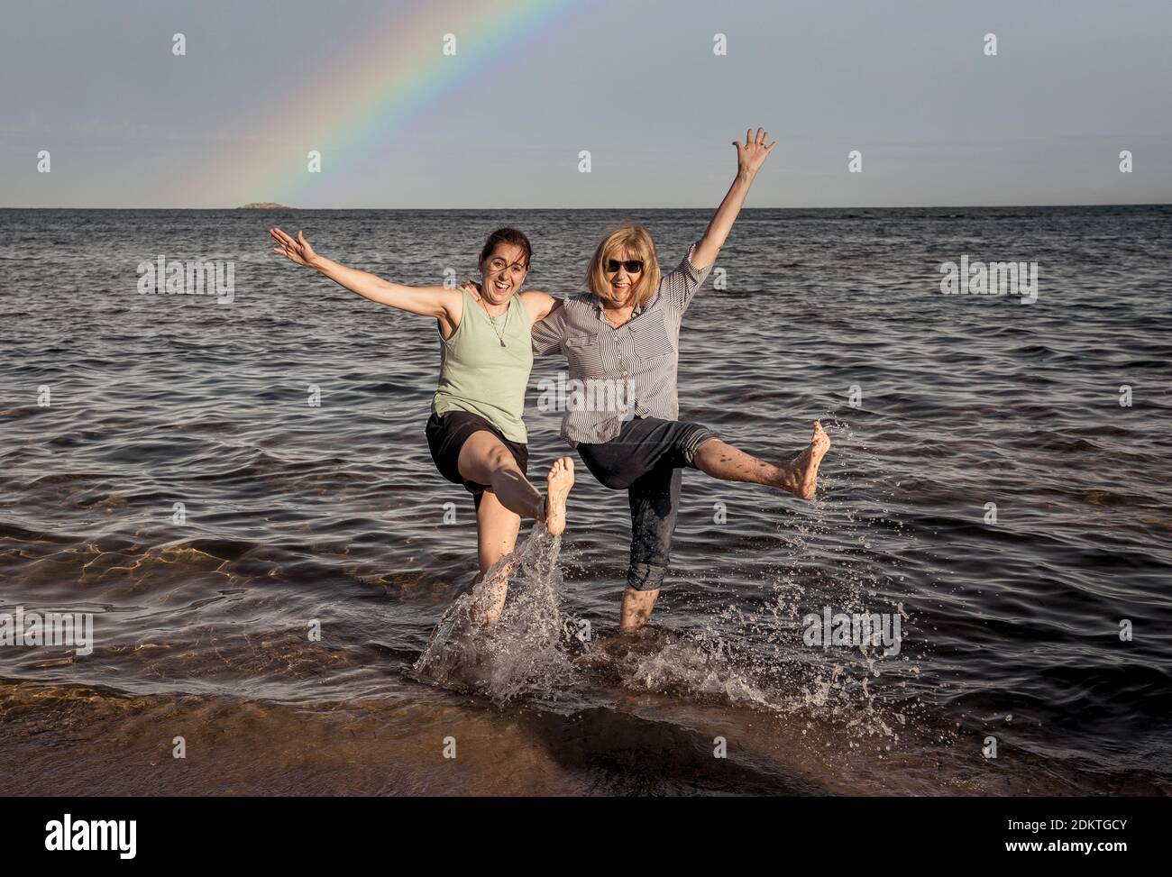 Senior Mother and adult daughter on remote beach enjoying outdoors life ...