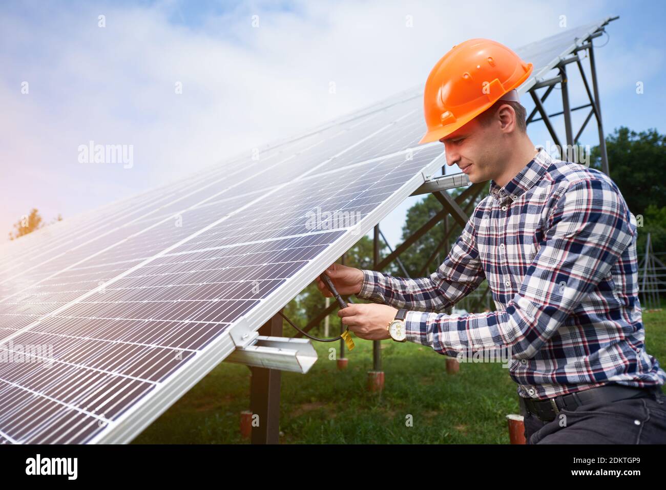 Worker checking connections of solar panels. Solar station development ...