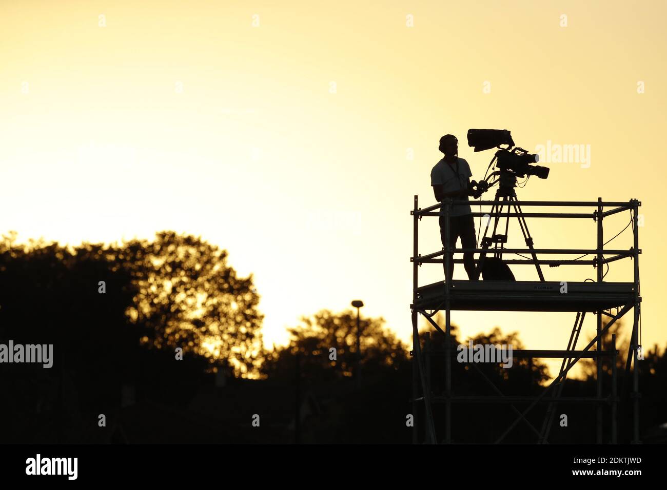 Cameraman on a platform filming a football game on a stadium, with a ...