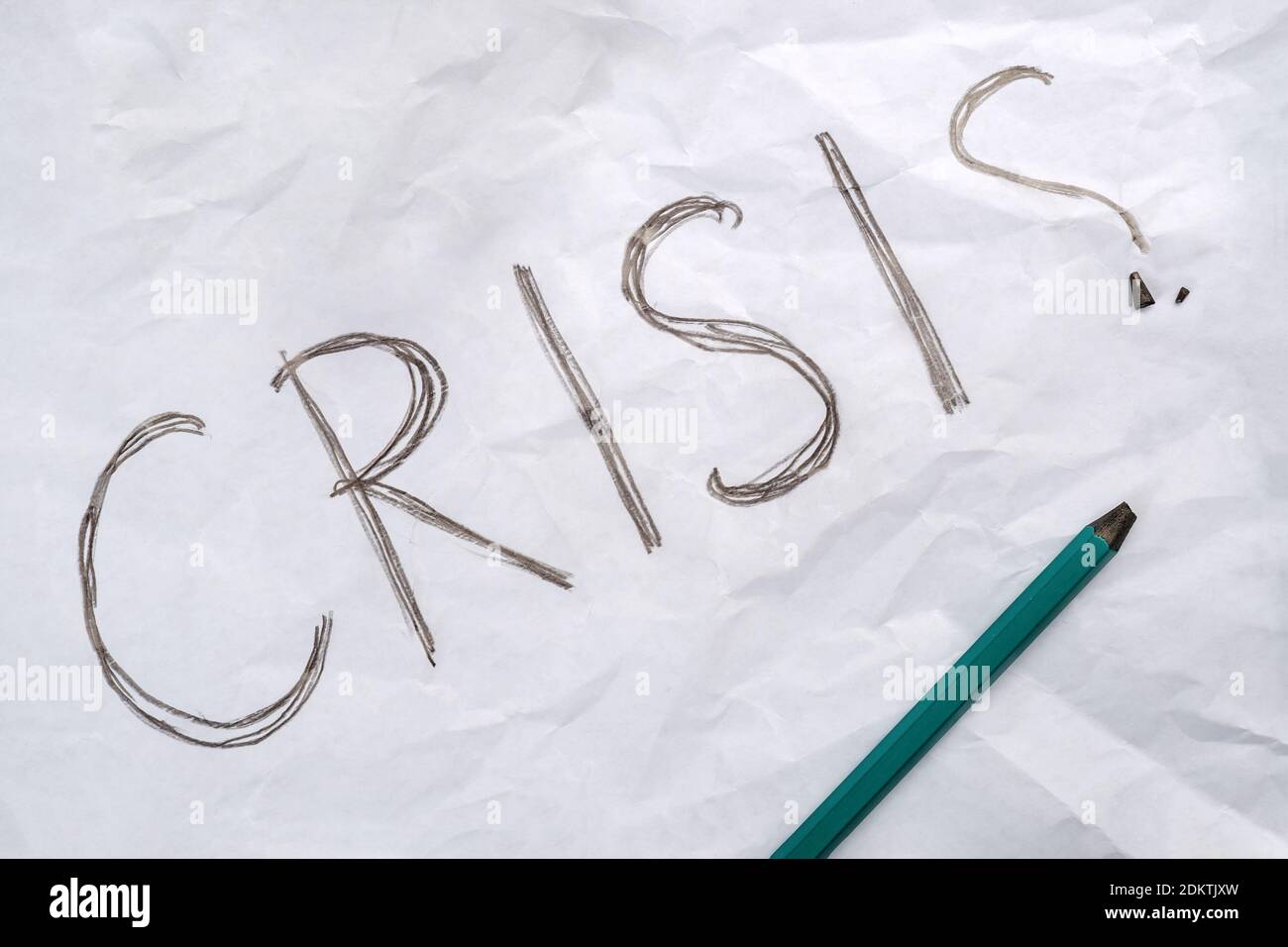 Unfinished text crisis, broken pencil on crumpled white paper sheet ...
