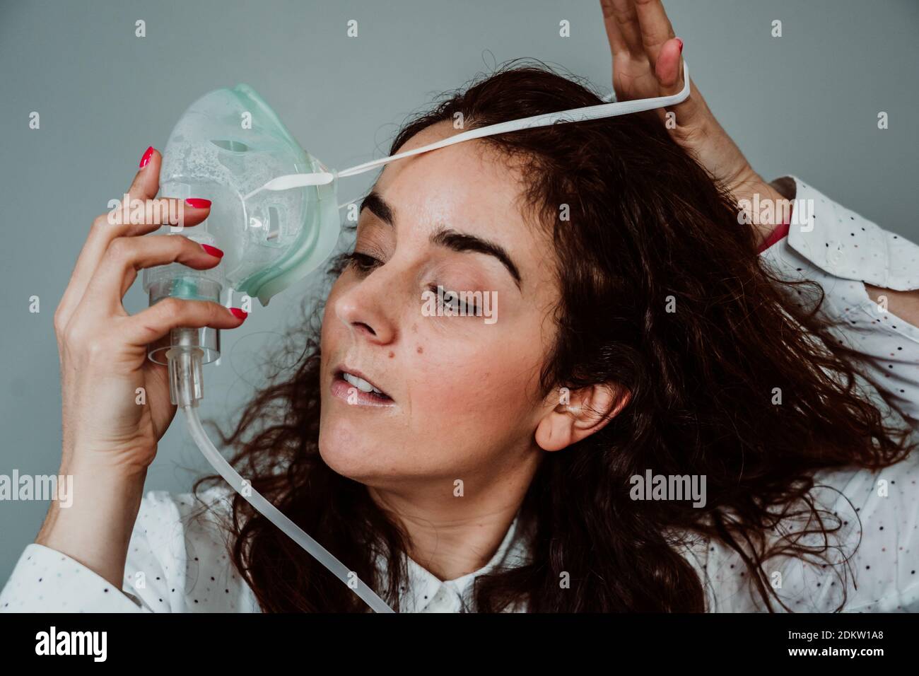 Woman Wearing Oxygen Mask Against Gray Background Stock Photo - Alamy