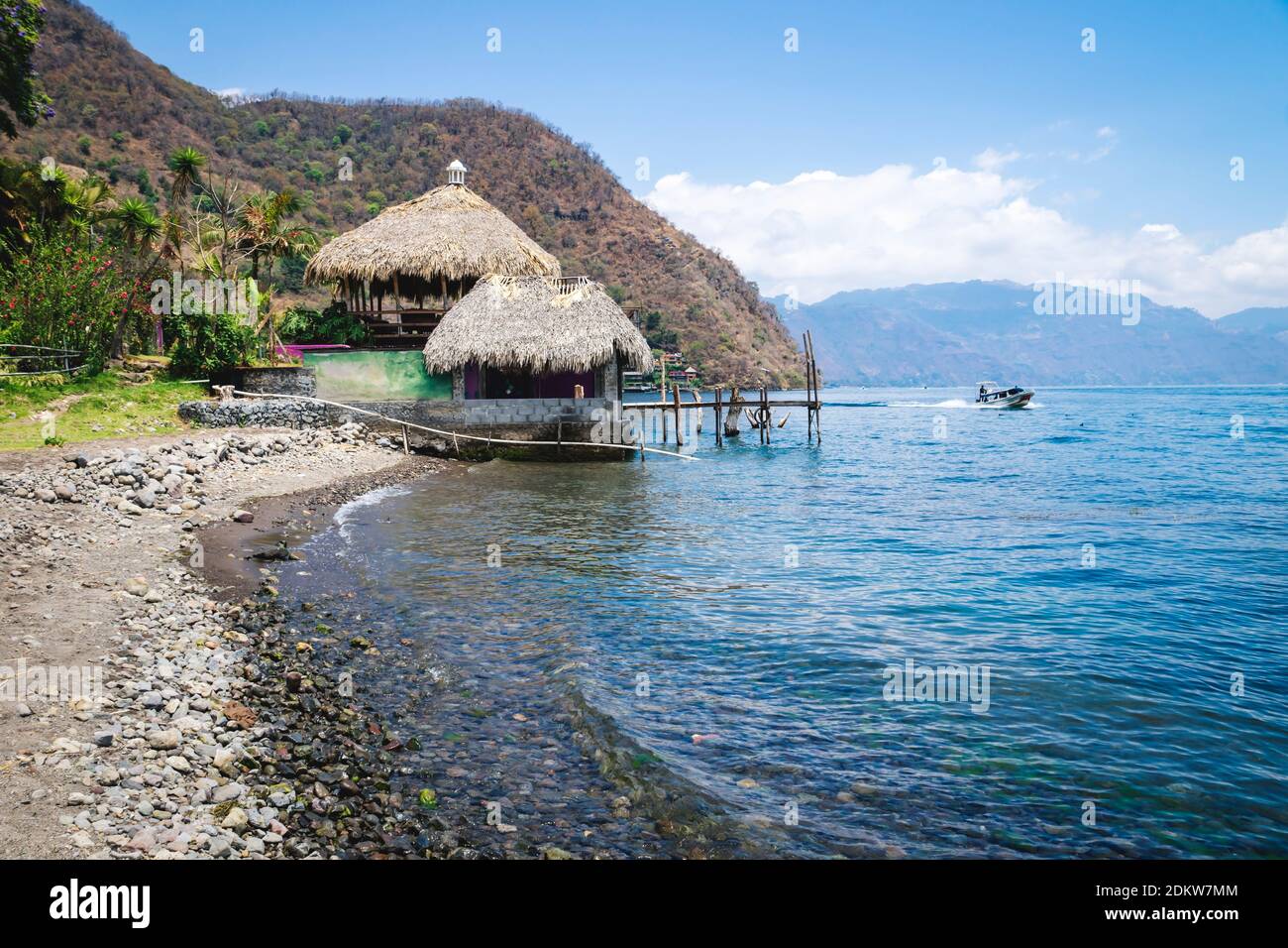 Jetty hut with straw roof at the mountain coast of lake Atitlan with ...