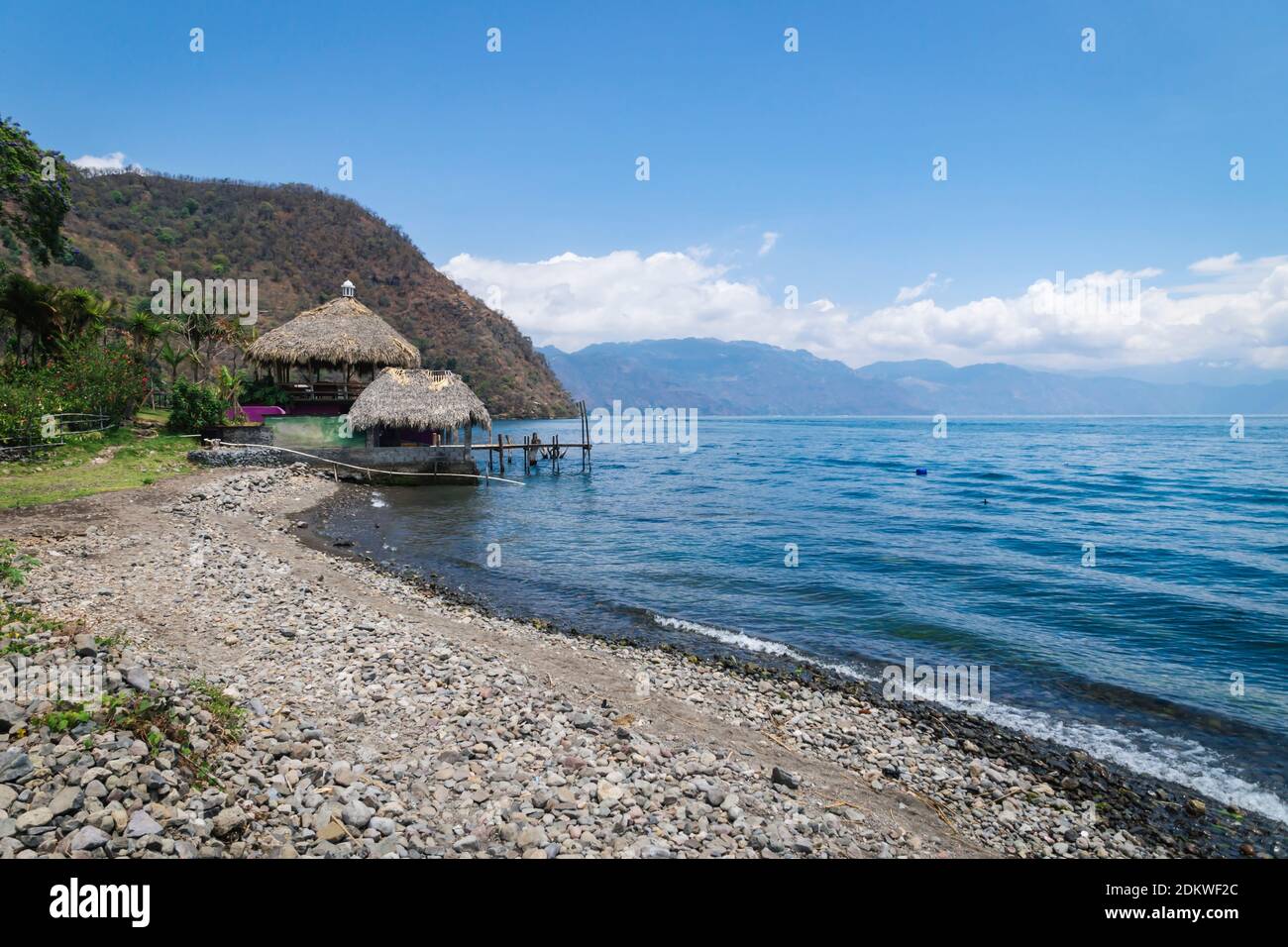Jetty hut with straw roof at the stone beach of lake Atitlan with ...