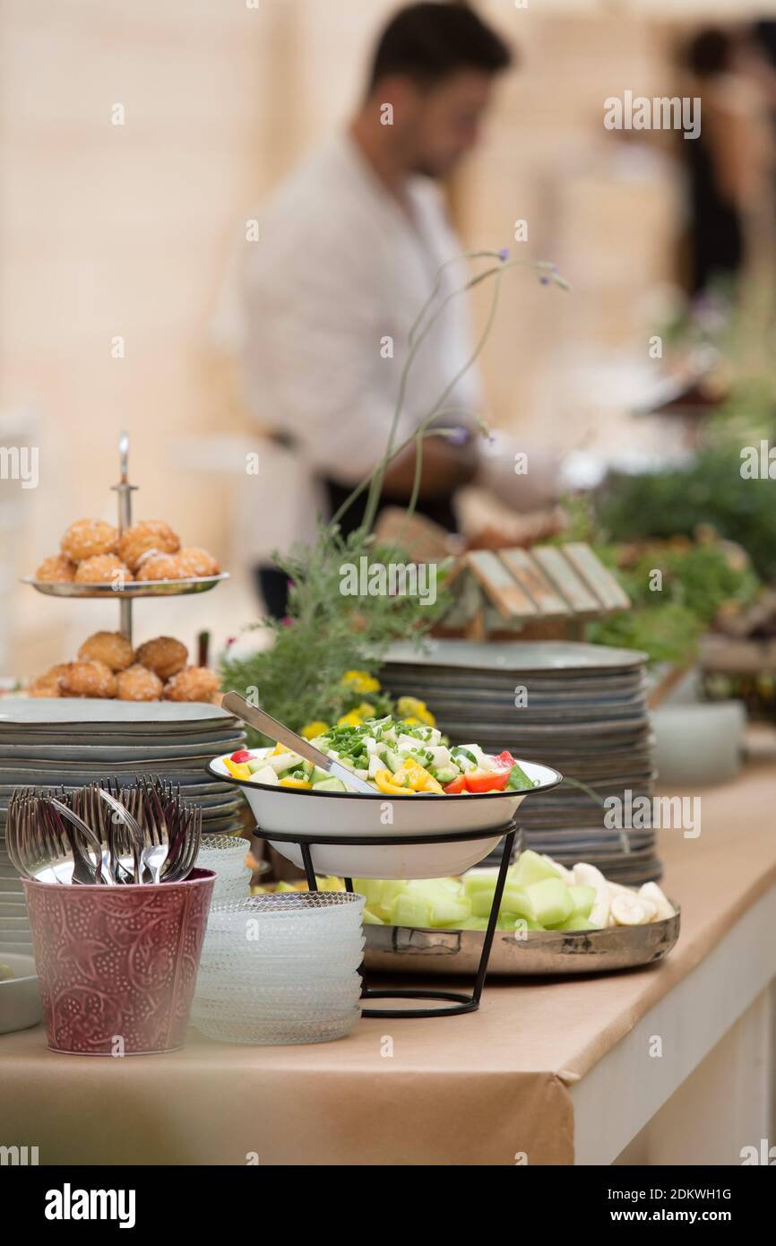 An assortment of foods in bowls on a buffet table during a evening ...