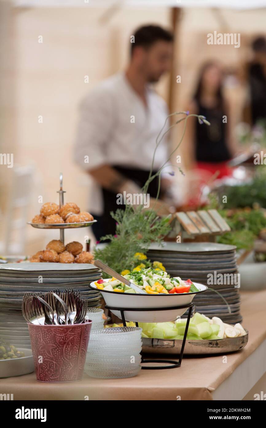 An assortment of foods in bowls on a buffet table during a evening ...