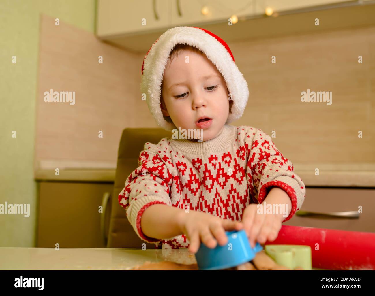Beautiful little boy cooking Christmas cookies. Santa Claus helper ...