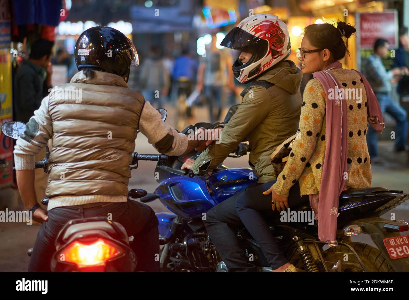 Young Nepalese people on their motorcycles greeting each other, on an ...