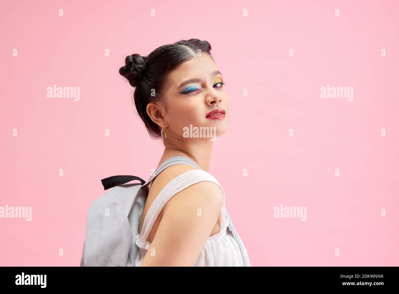 Fashionable young girl wears holding backpack, posing isolated on pink ...