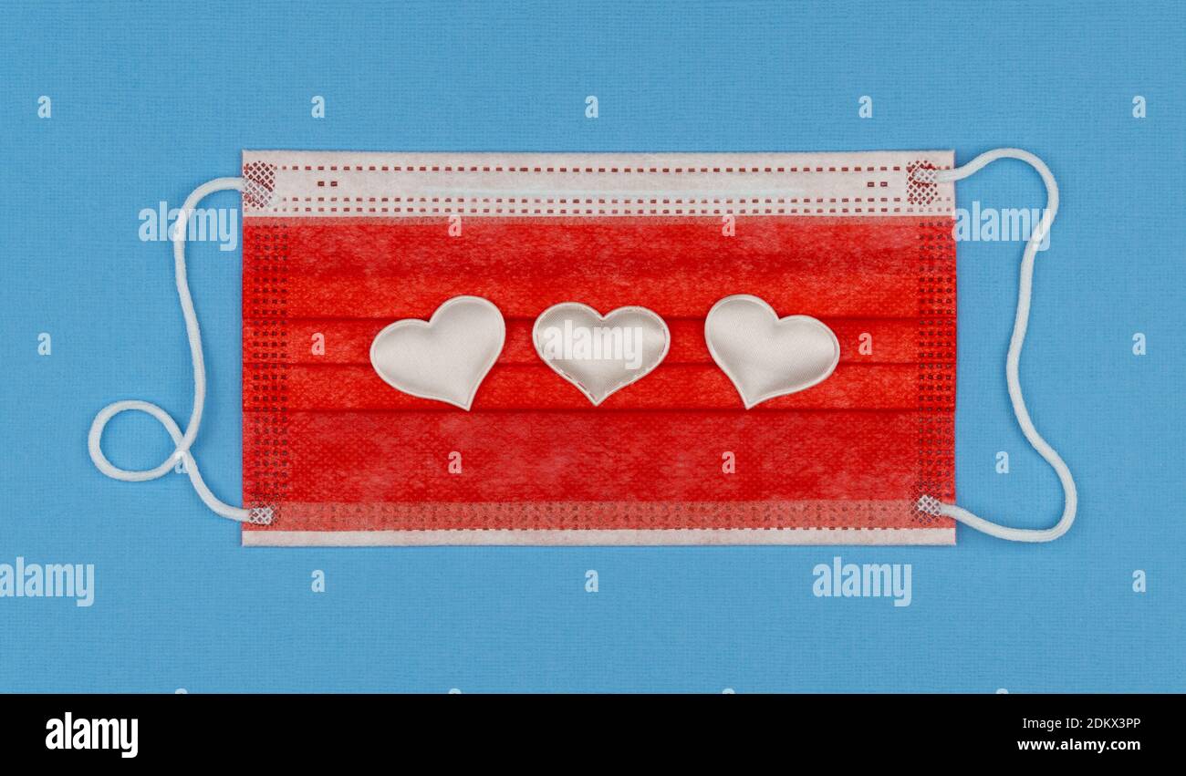 medical mask of red color with hearts on a blue background. Medical ...