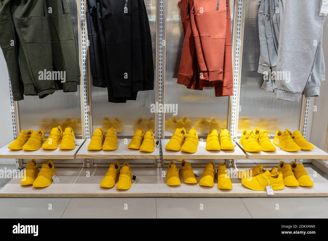 Rows of yellow Sneakers, pants hanging over them. Gray and yellow ...