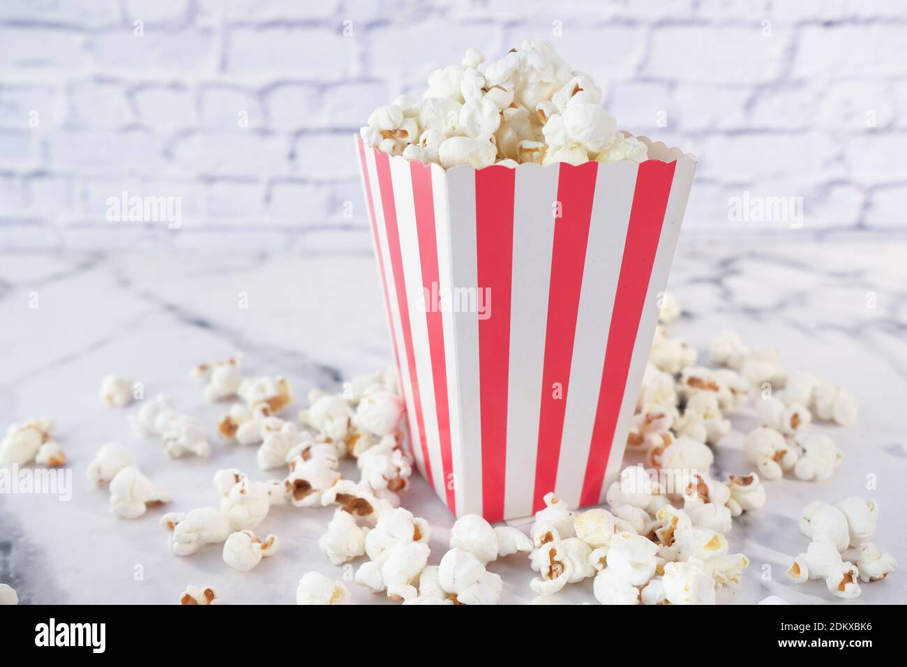 popcorn spilling from a container on white background Stock Photo - Alamy