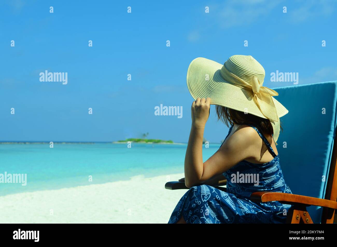 Side View Of Woman Sitting On Chair At Beach Stock Photo - Alamy