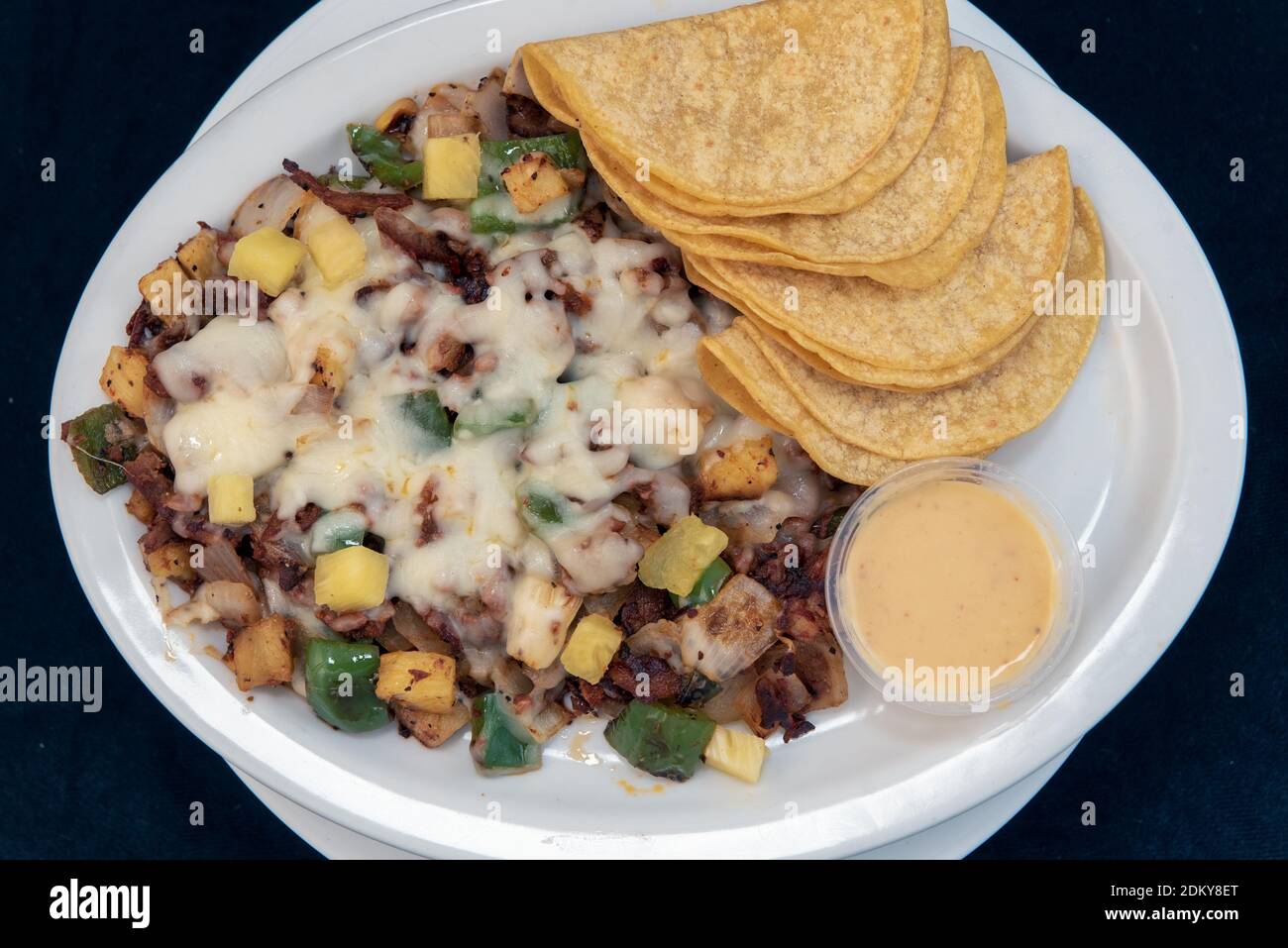 Overhead view of alambre plate of grilled meat, chopped vegetables, and ...