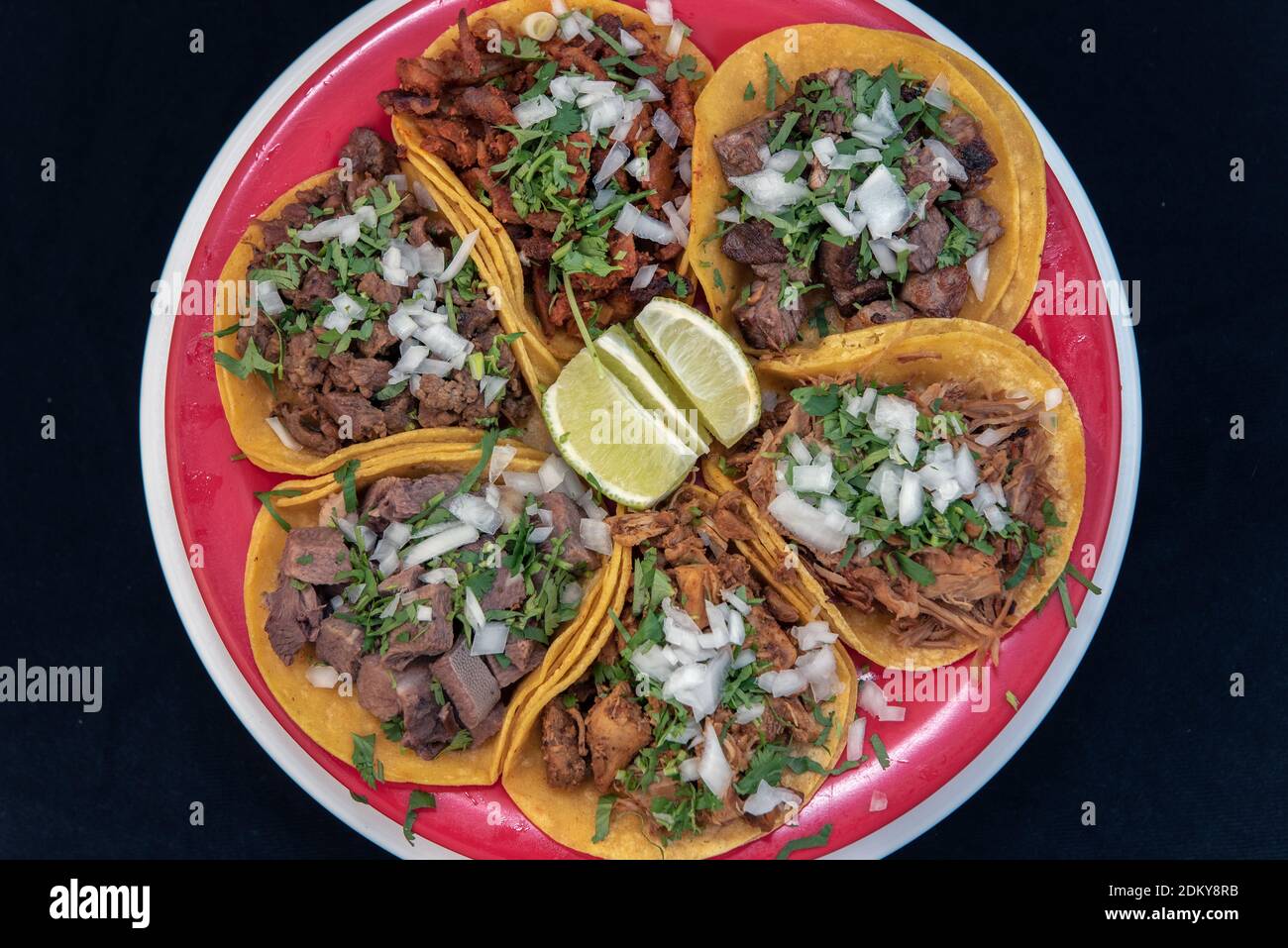 Overhead view of assortment sampler platter of street tacos loaded with ...