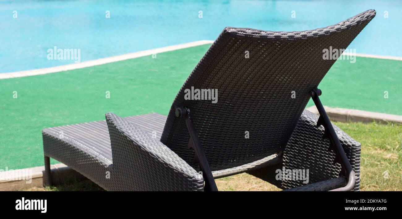 Brown beach sun chaise lounge chair near swimming pool, vacation ...