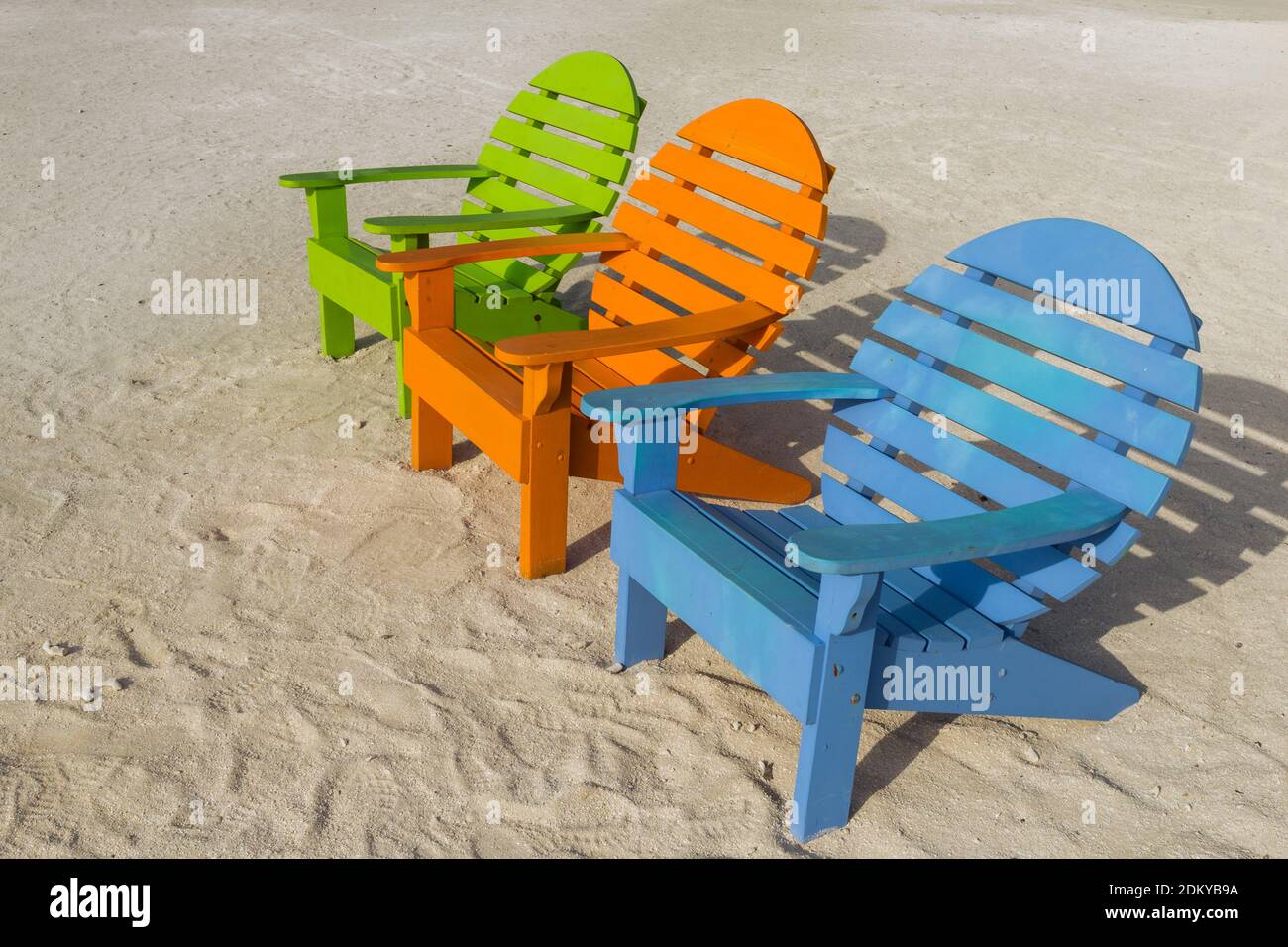 Three chairs of different color on a beach in Belize Stock Photo - Alamy