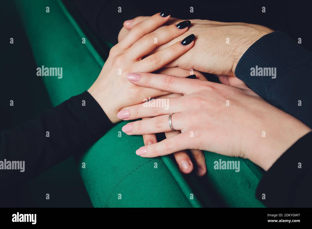 two man and three women holding hands on a table implying a polyamory ...