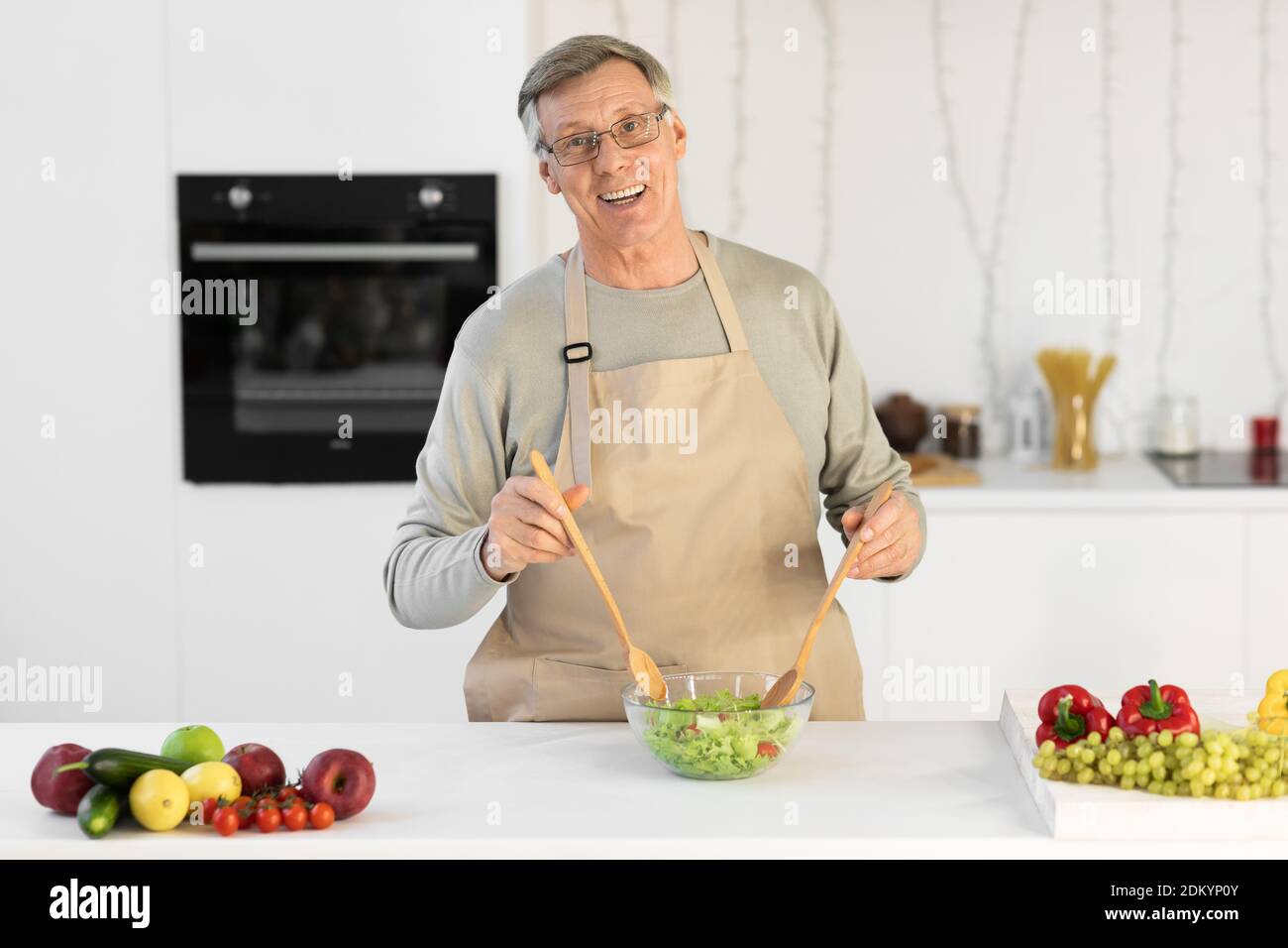 Senior Man Cooking Standing Smiling To Camera In Modern Kitchen Stock ...
