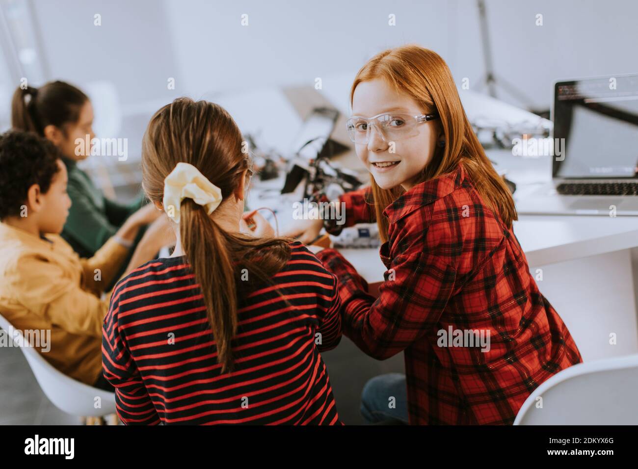 Group of happy kids programming electric toys and robots at robotics ...