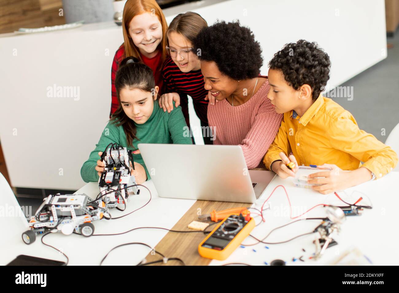 Group of happy kids with their African American female science teacher ...