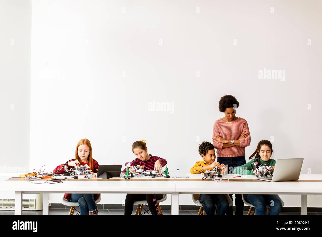 Group of happy kids with their African American female science teacher ...