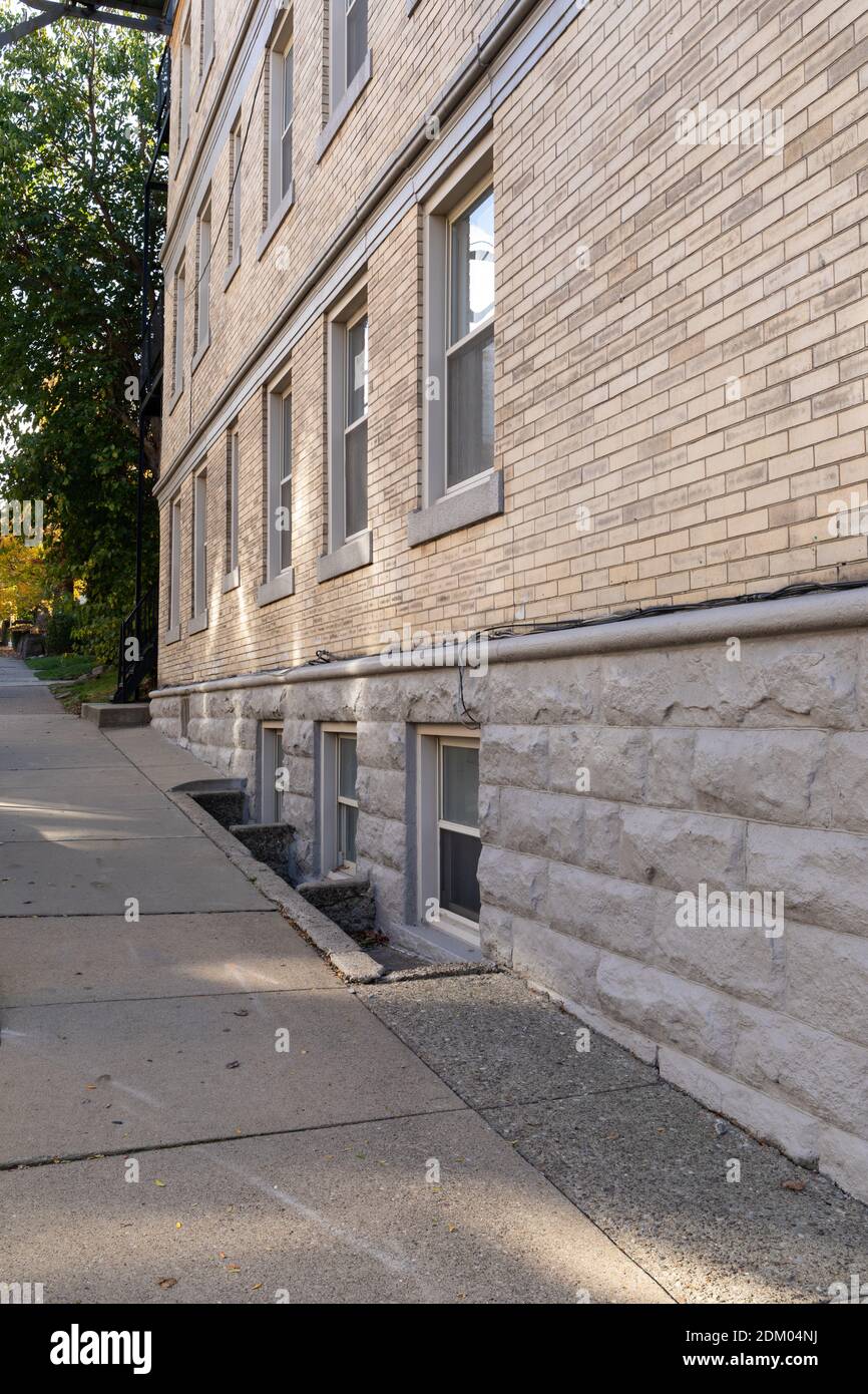 Angled view of inclined sidewalk and building of tan brick and ...