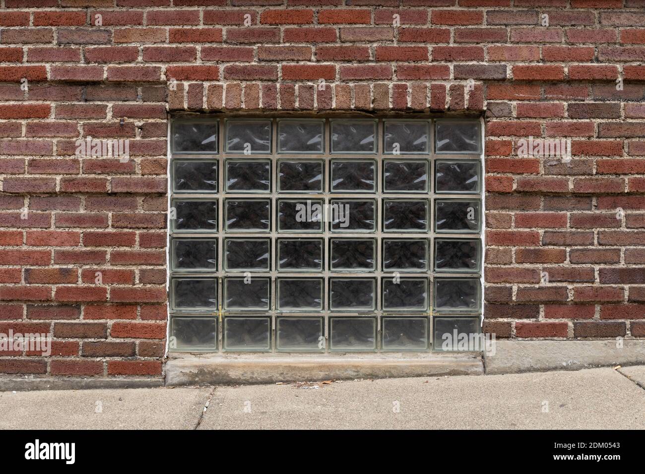 Straight on view of a basement window with glass brick blocks inset ...
