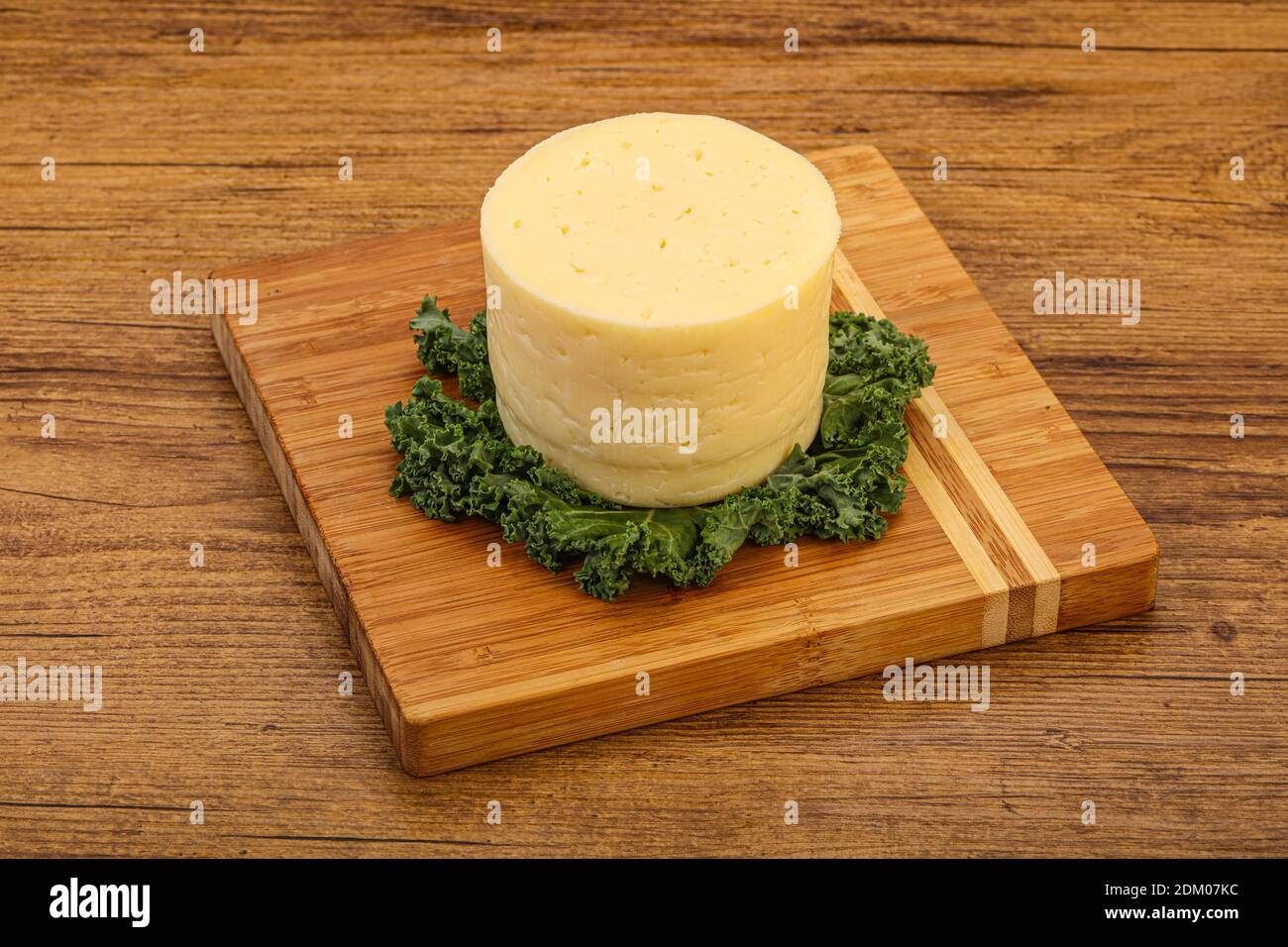 Yellow round dairy soft cheese piece Stock Photo - Alamy