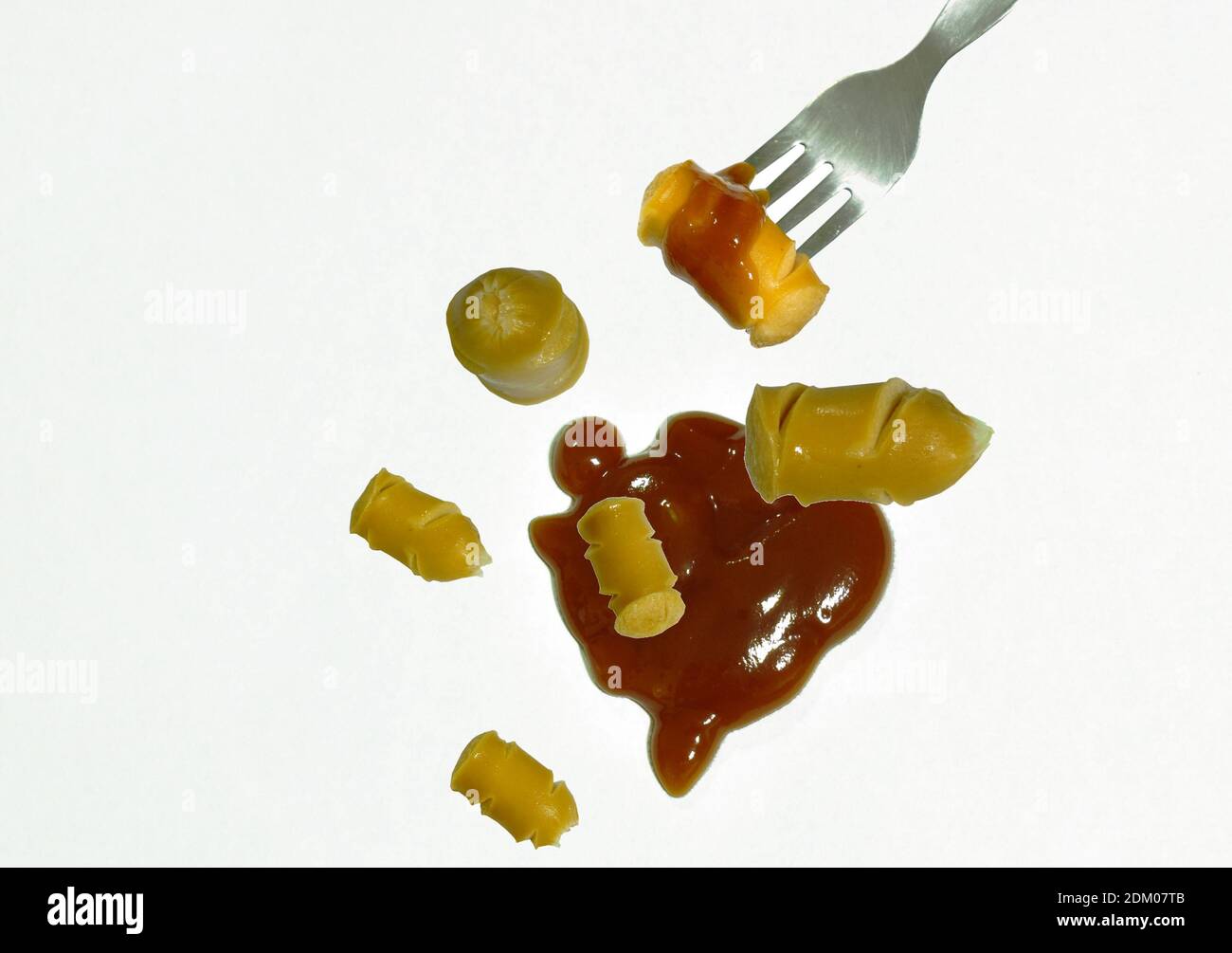 fried pork sausage slice stabbing in silver fork and dressing ketchup ...