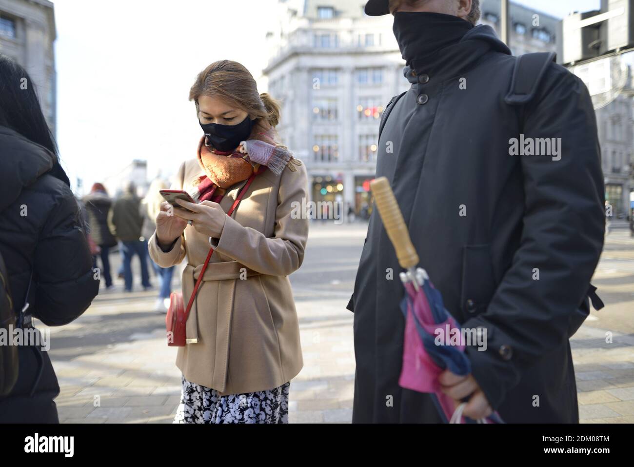 London, England, UK. Asian woman checking her mobile phone in Regent ...