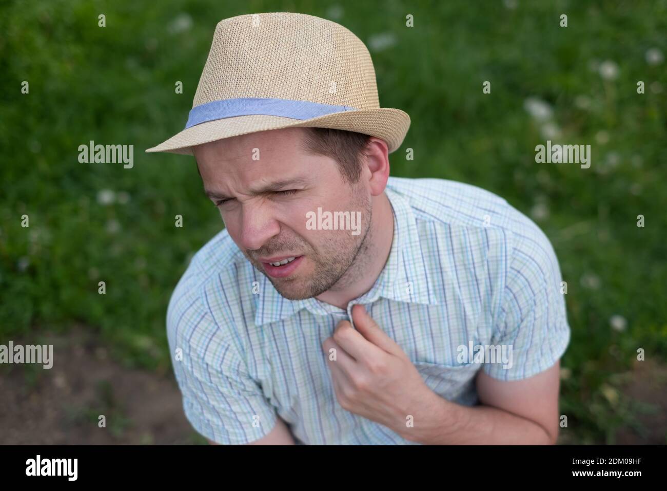 Stressed man sweating suffering heat stroke a warm day in summer ...
