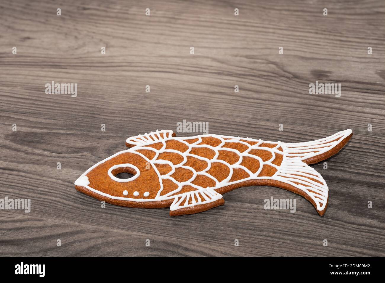 Sweet fish baked from Christmas gingerbread cookie on a wood background ...