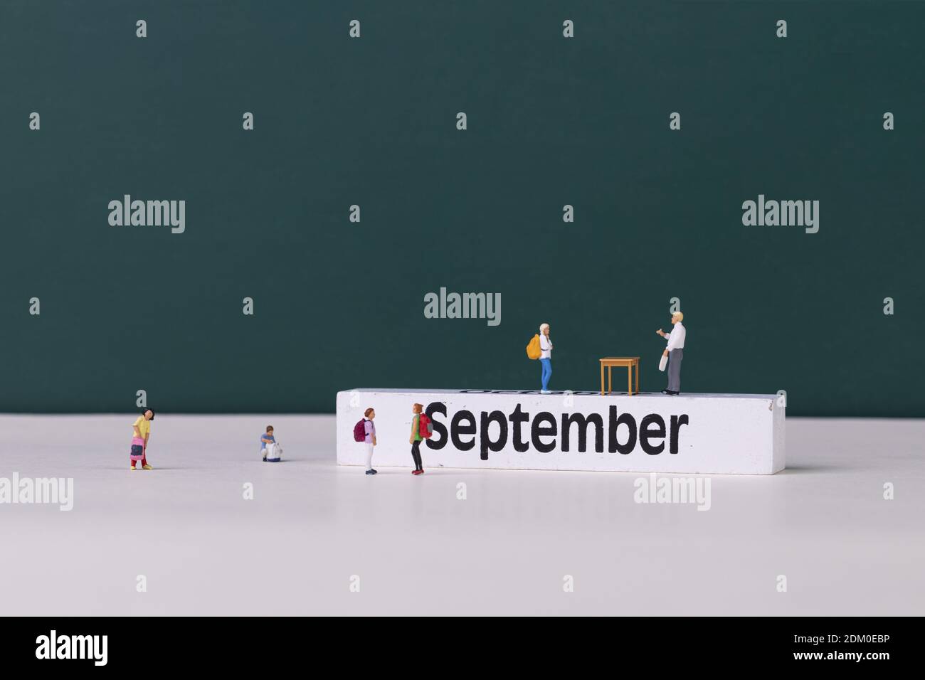A teacher and student figurines around the September calendar depicting ...