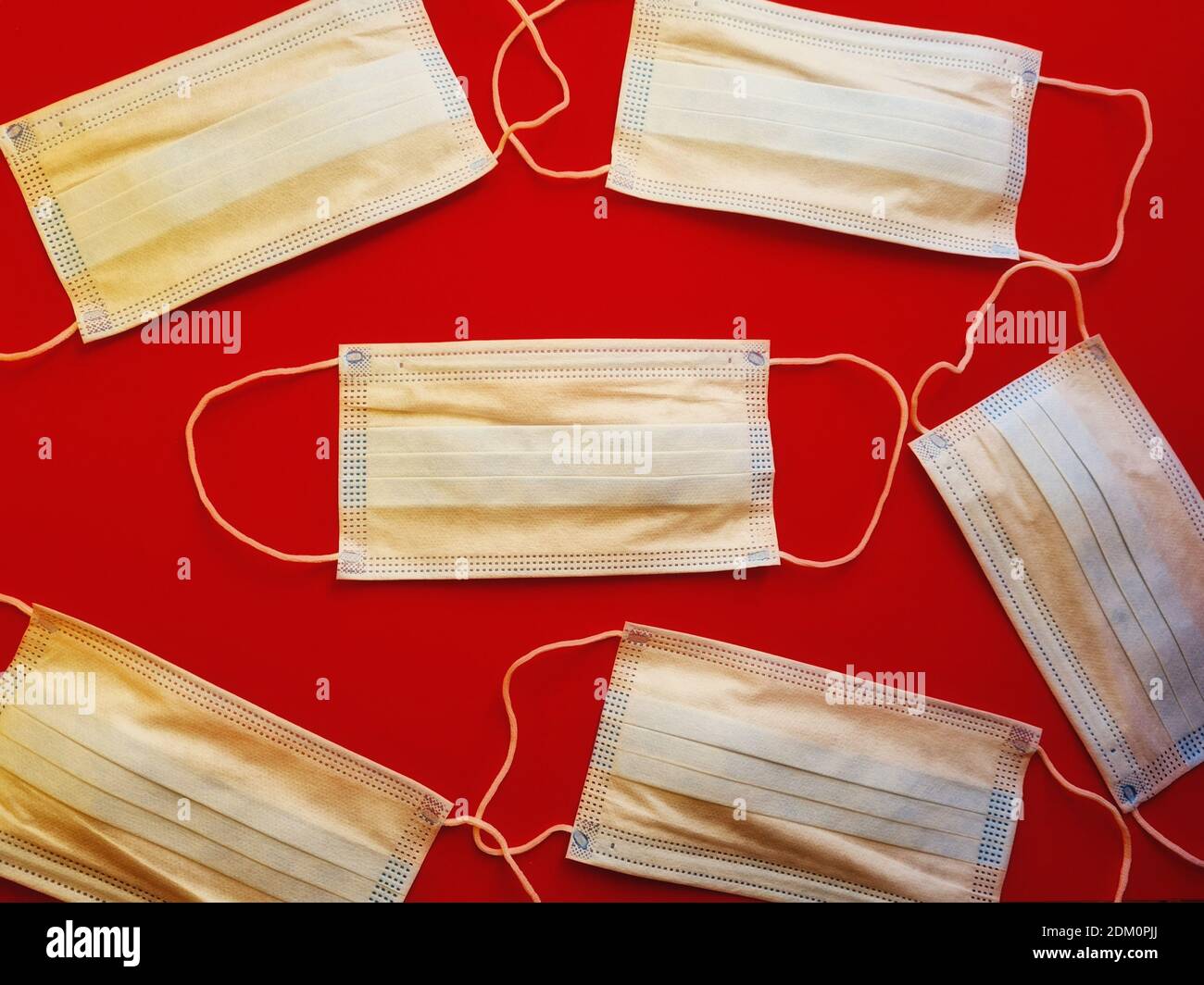 A top view of surgical protective masks laying on red isolated ...