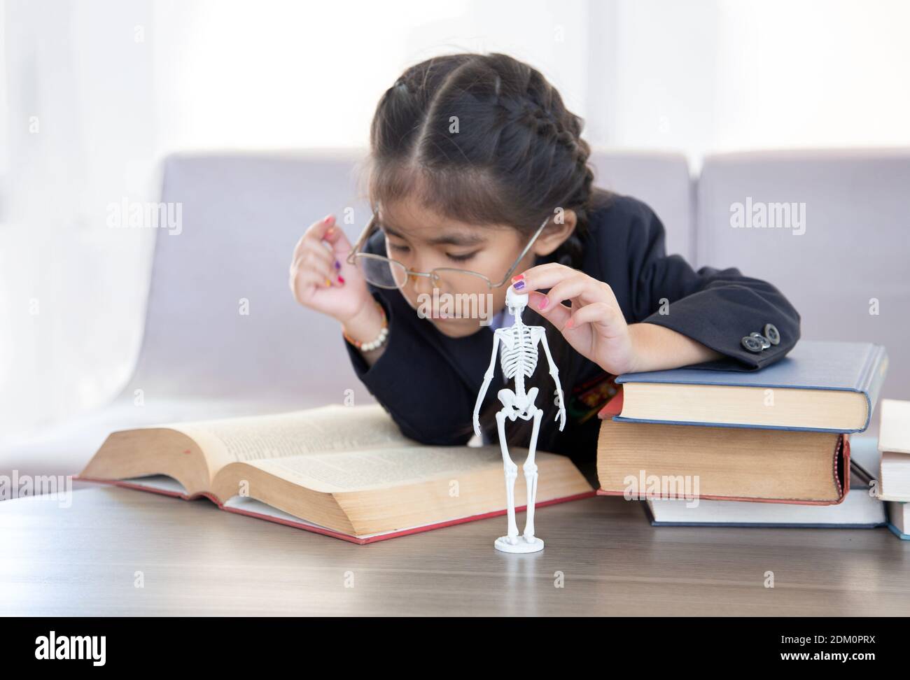 Girl Reading Book On Table At Home Stock Photo - Alamy
