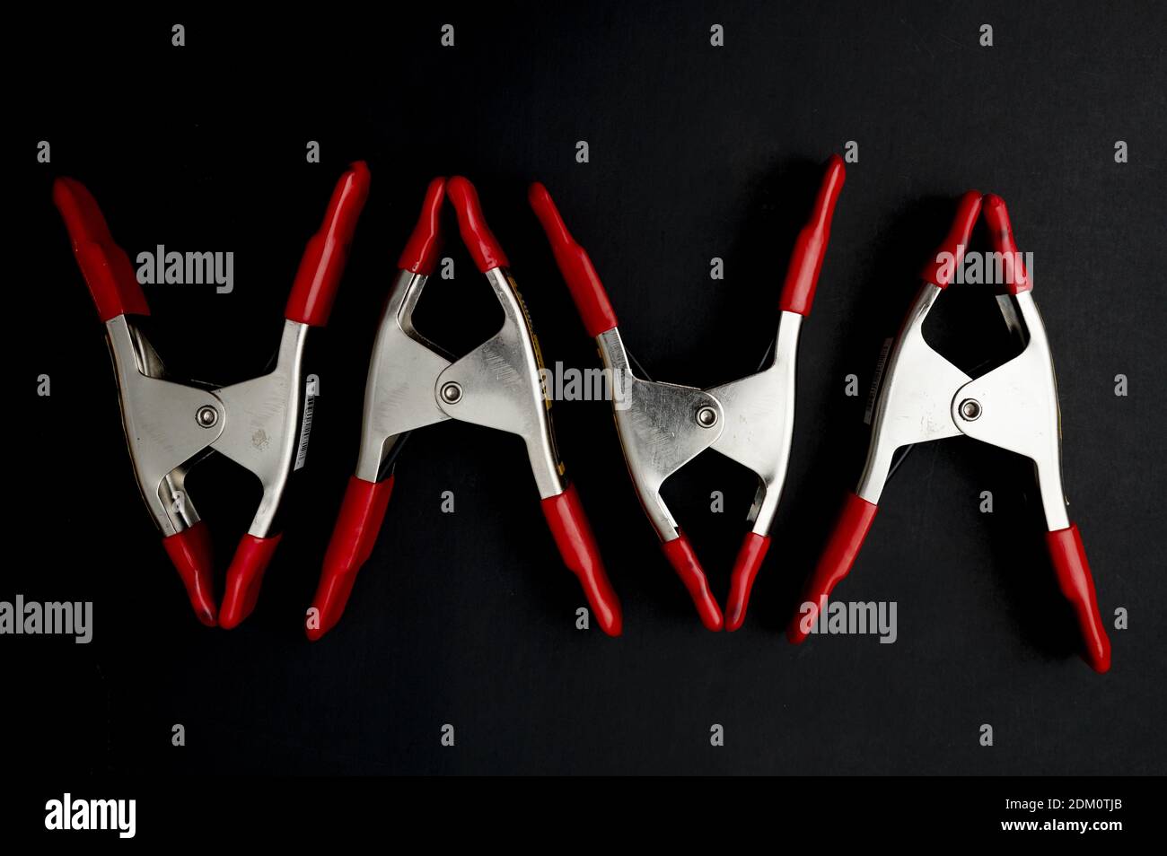 A top view metal clothespins on a black background Stock Photo - Alamy