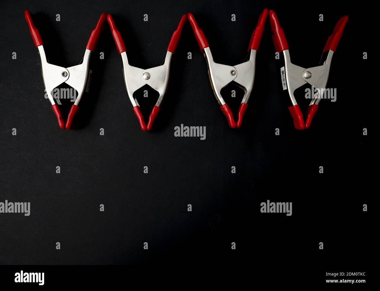 A top view metal clothespins on a black background Stock Photo - Alamy