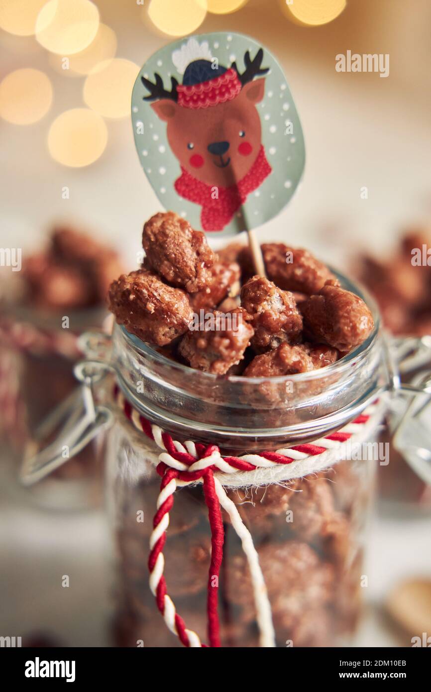 A vertical shot of delicious Christmas roasted almonds in a jar on a ...