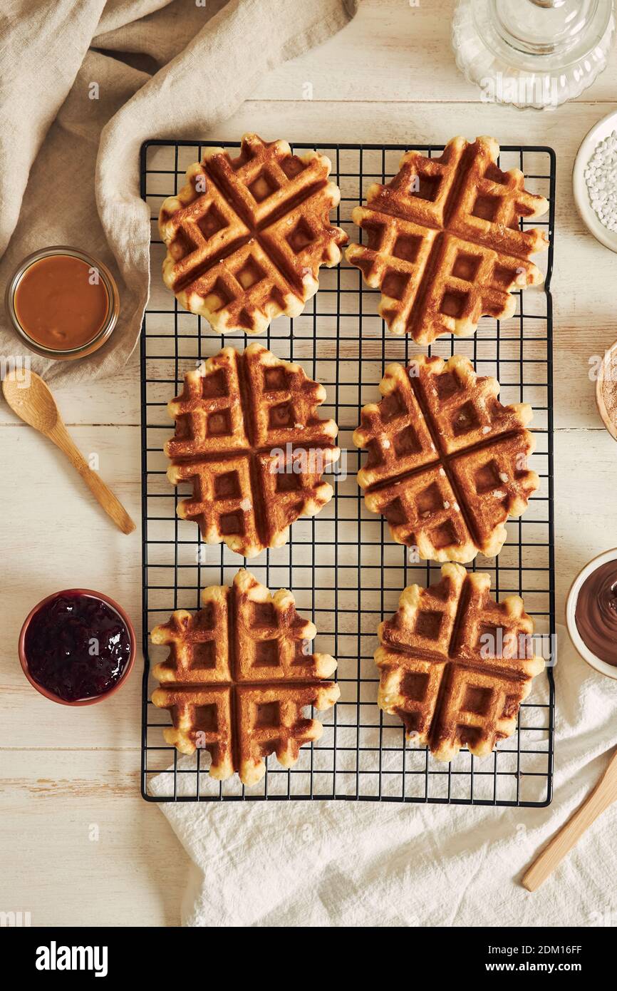 A vertical shot of delicious waffles in a tray on a white table Stock ...