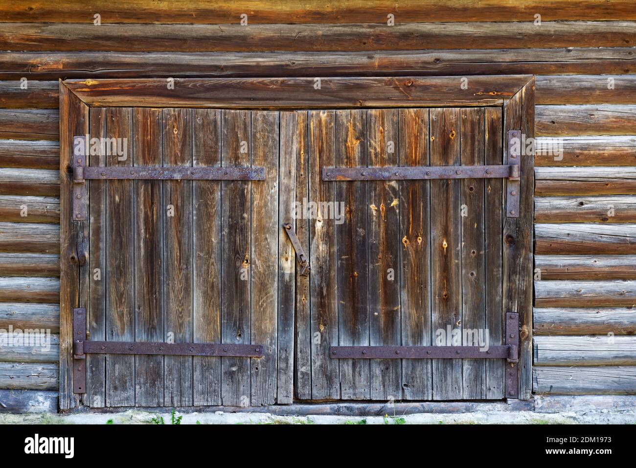 Wooden gate in an old log building. Front view. Texture background ...