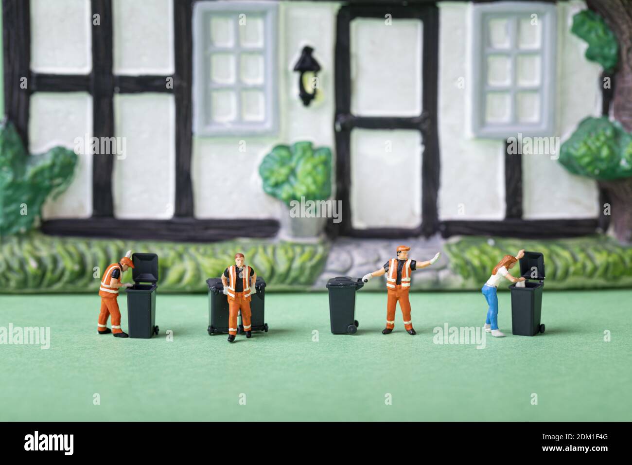 A selective focus shot of waste collector toys and a toy lady throwing ...