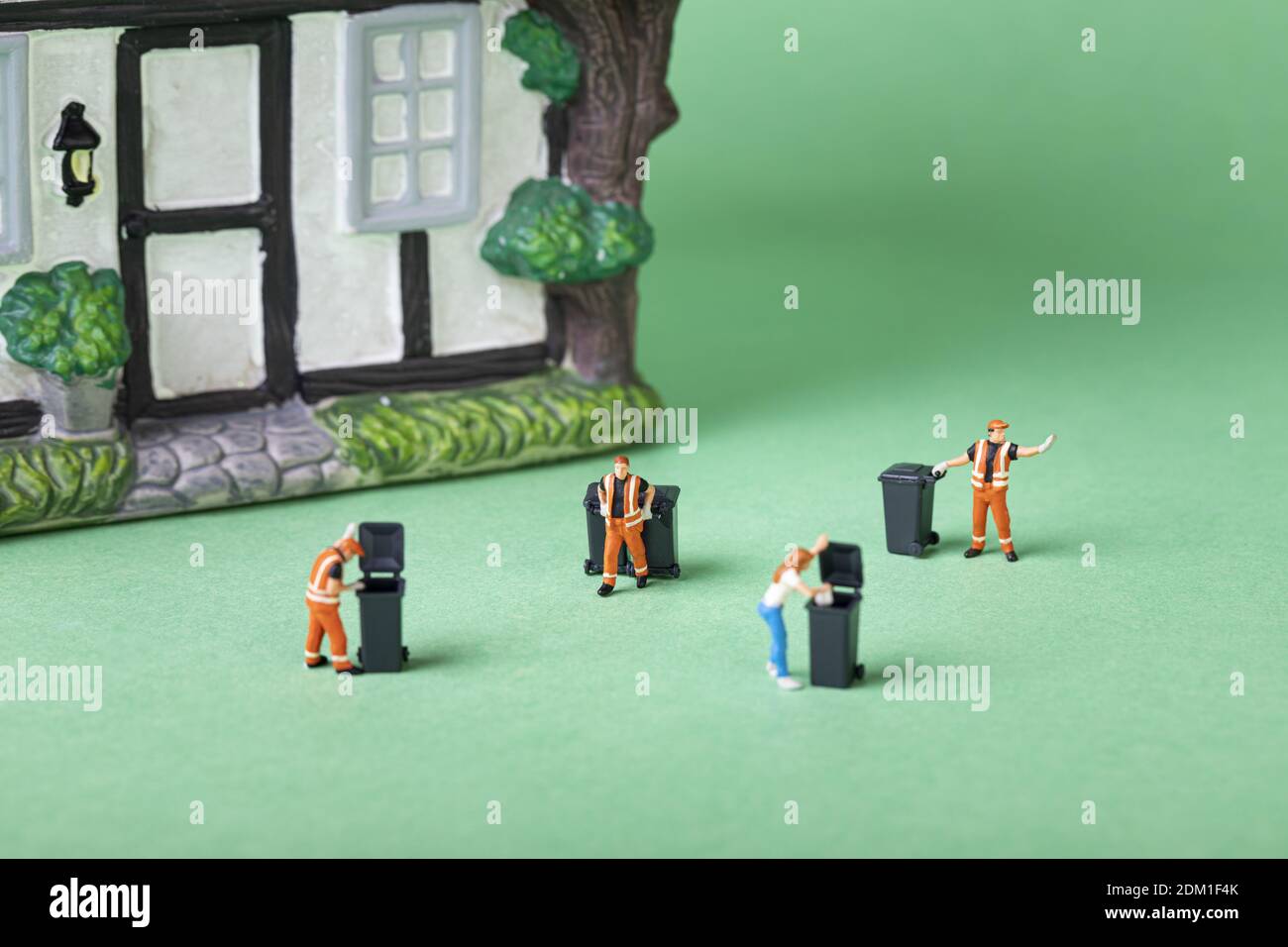 A closeup shot of waste collector toys and a toy lady throwing garbage ...