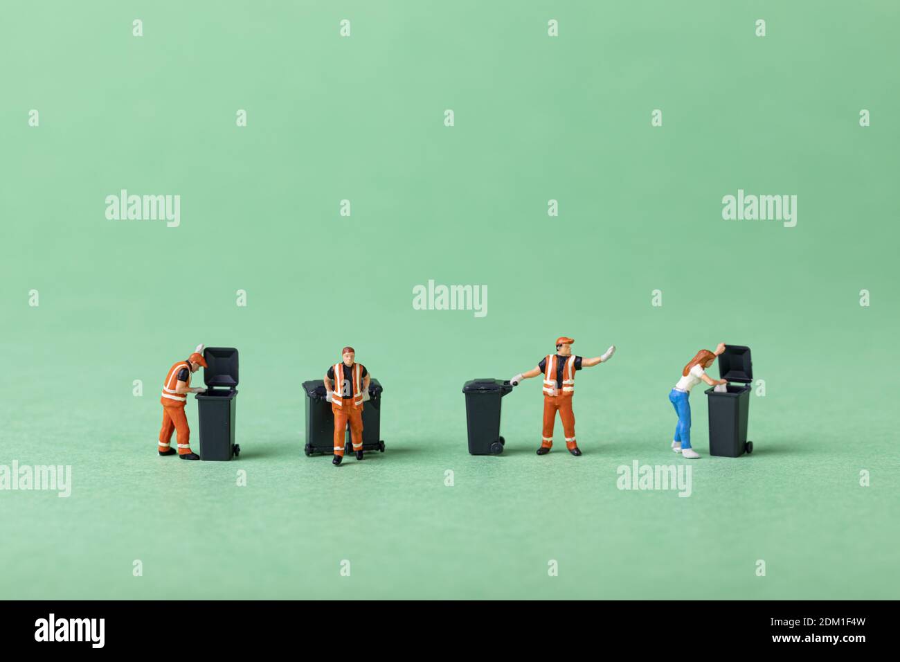 A closeup shot of waste collector toys and a toy lady throwing garbage ...