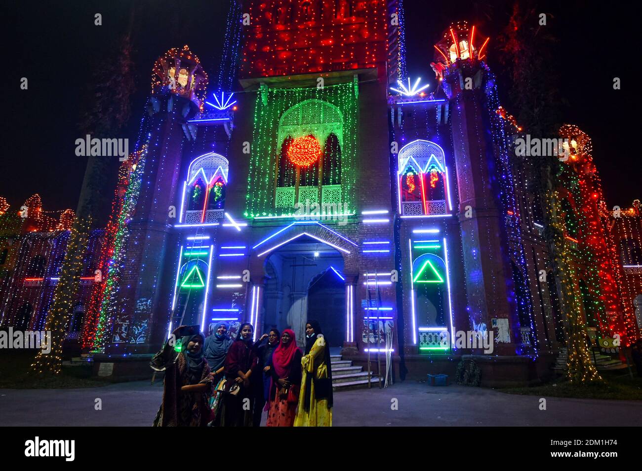 Dhaka. 16th Dec, 2020. People pose for photos amid colourful lighting ...