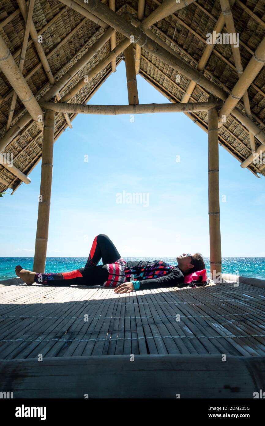 Woman Lying In Hut At Beach Stock Photo - Alamy