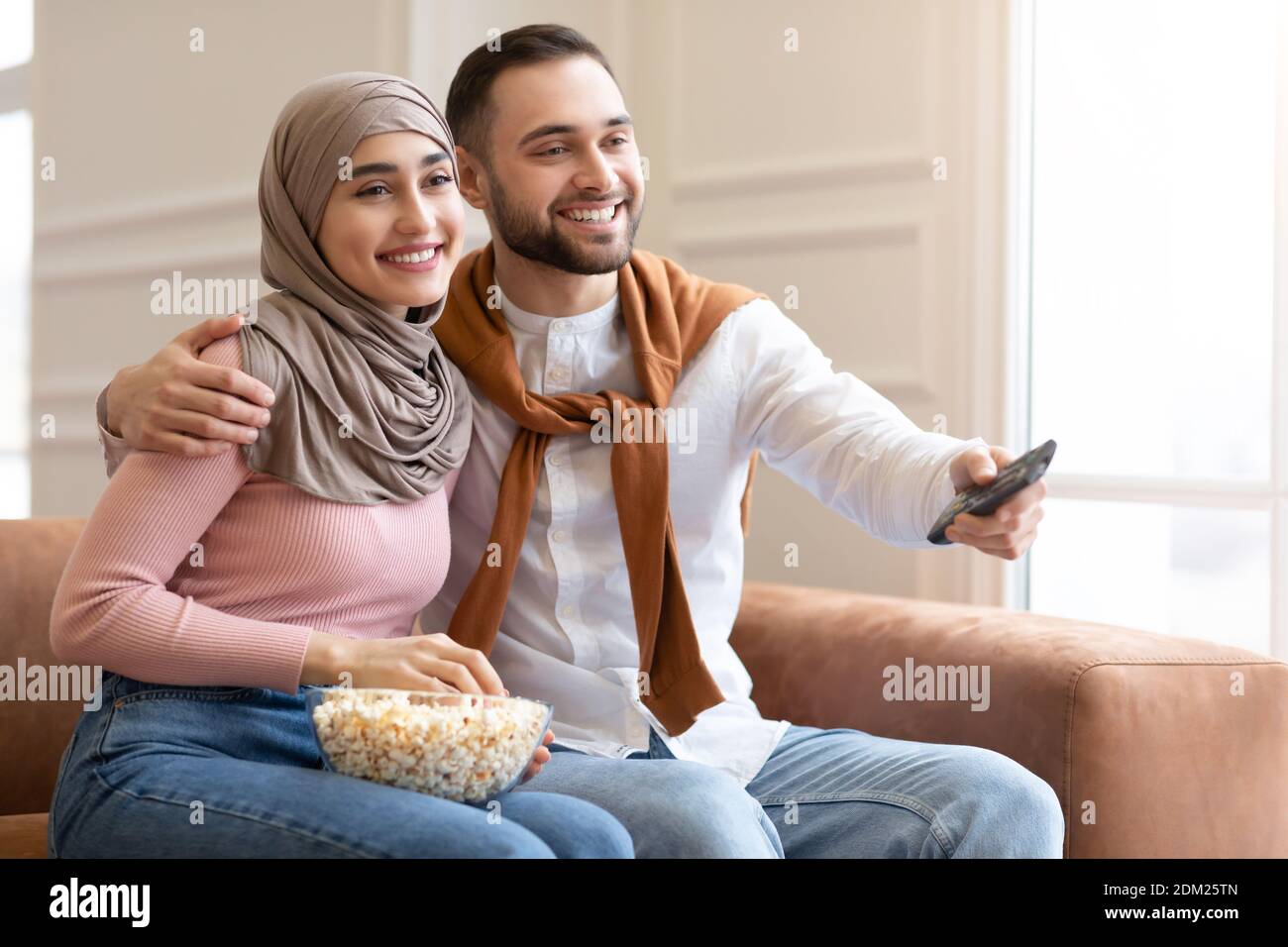 Cheerful Muslim Couple Watching Movie On TV In Living Room Stock Photo ...