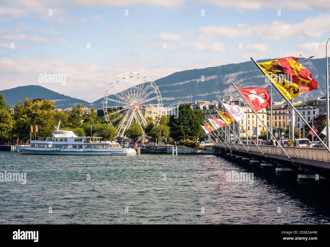 Flags of Geneva and Swiss flags flying on a bridge on the Lake Geneva ...